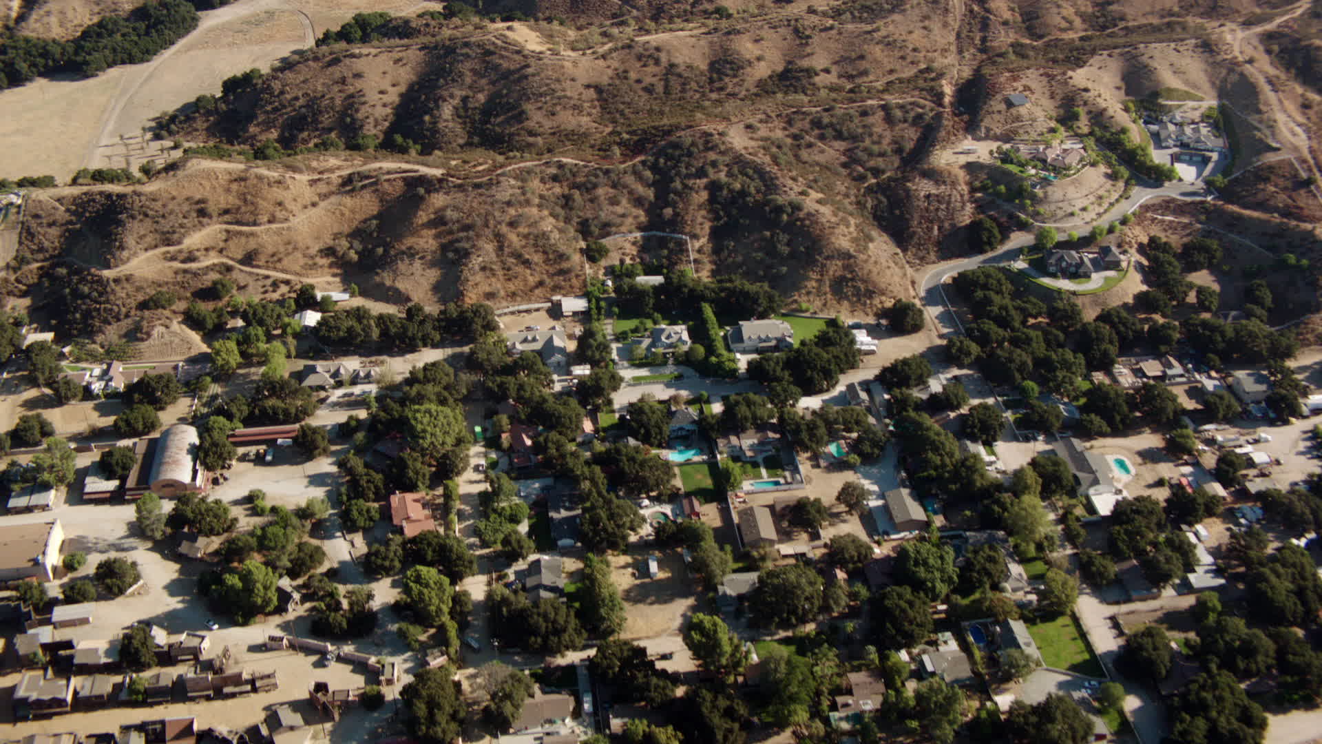 HD stock footage aerial video fly over homes and brown hills in Newhall ...